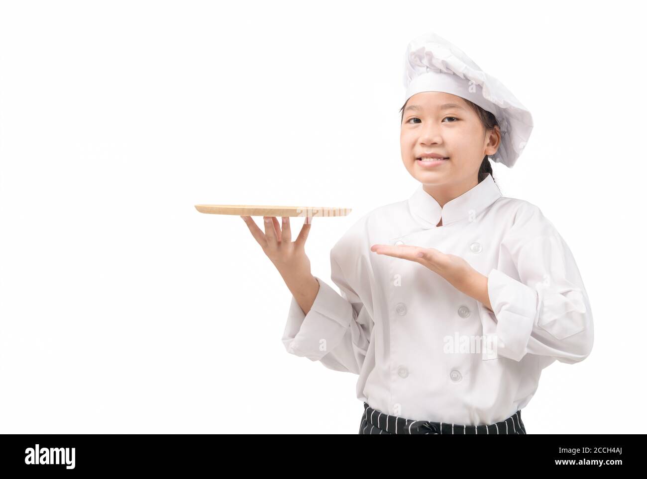 Portrait Happy little chef in uniform presenting dish and smiling ...