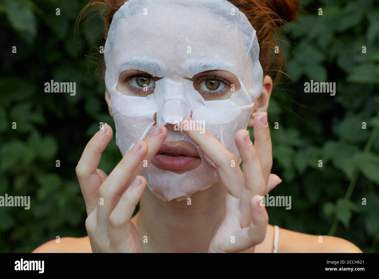 Nice woman Anti-wrinkle mask press your face with your fingers ...