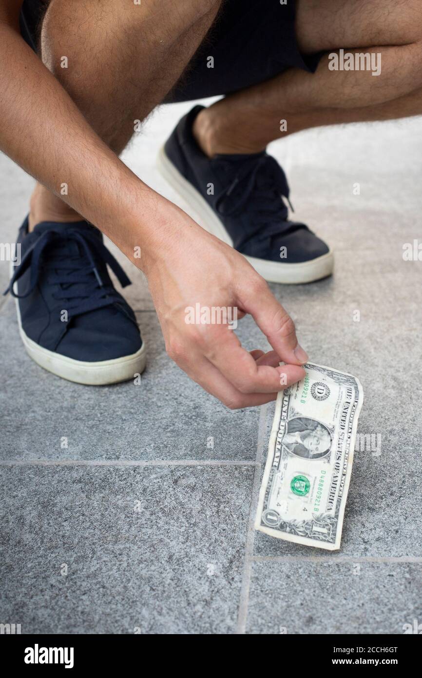 anonymous Man, casual dressed, with blue sneakers, picking up one ...