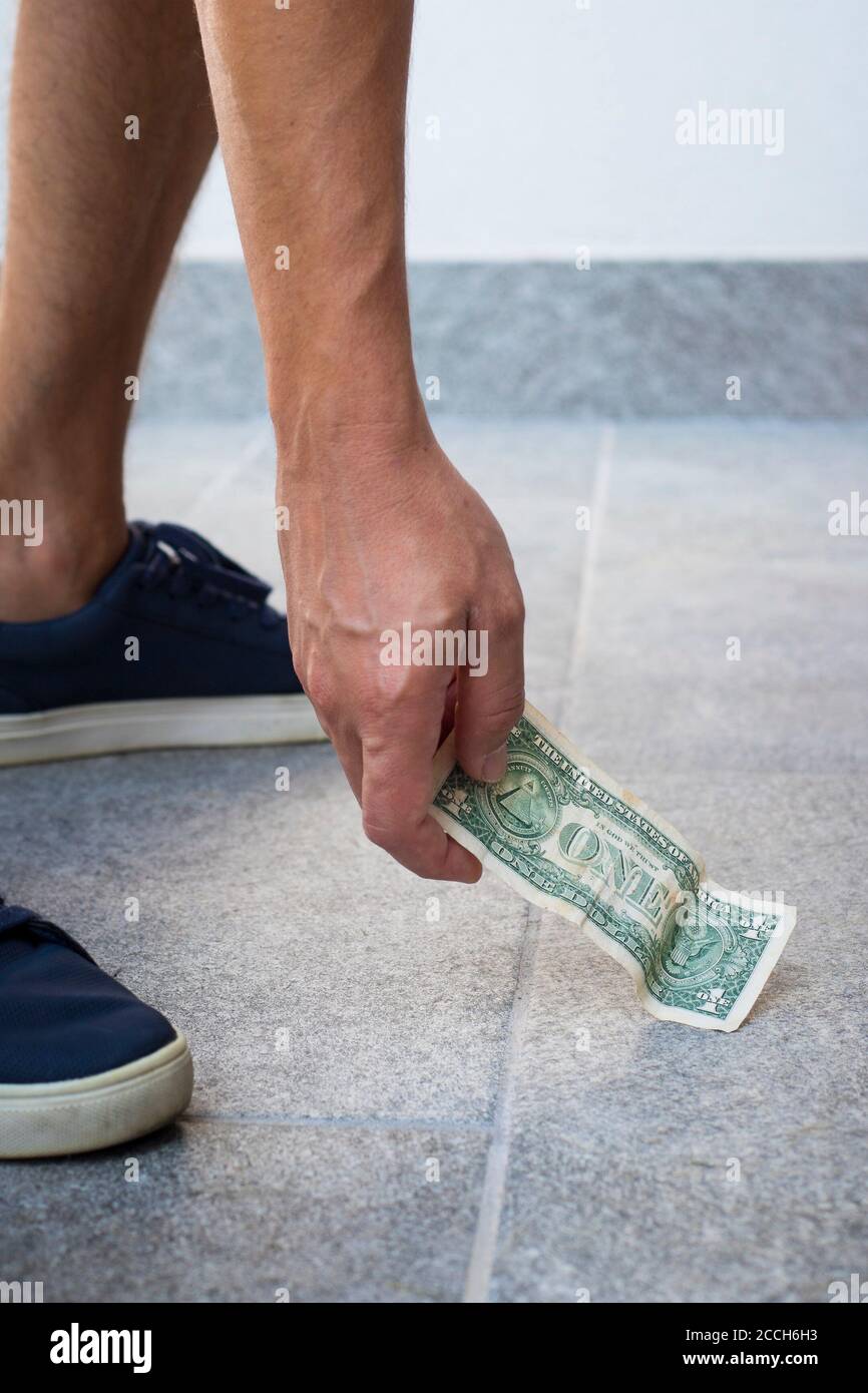Anonymous man, casual dressed, with blue sneakers, picking up one ...