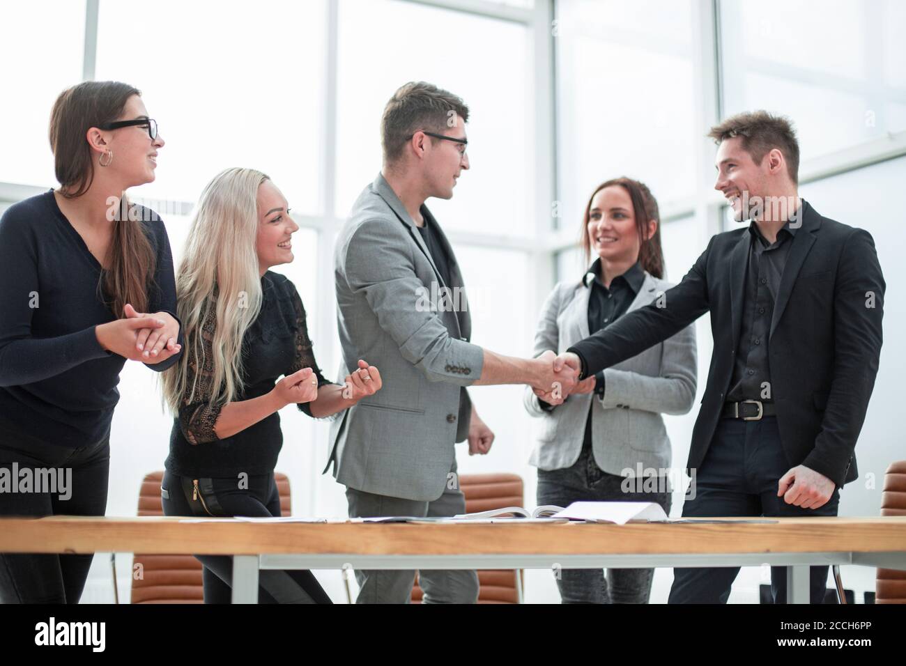close up. happy employees applaud and shake hands Stock Photo - Alamy