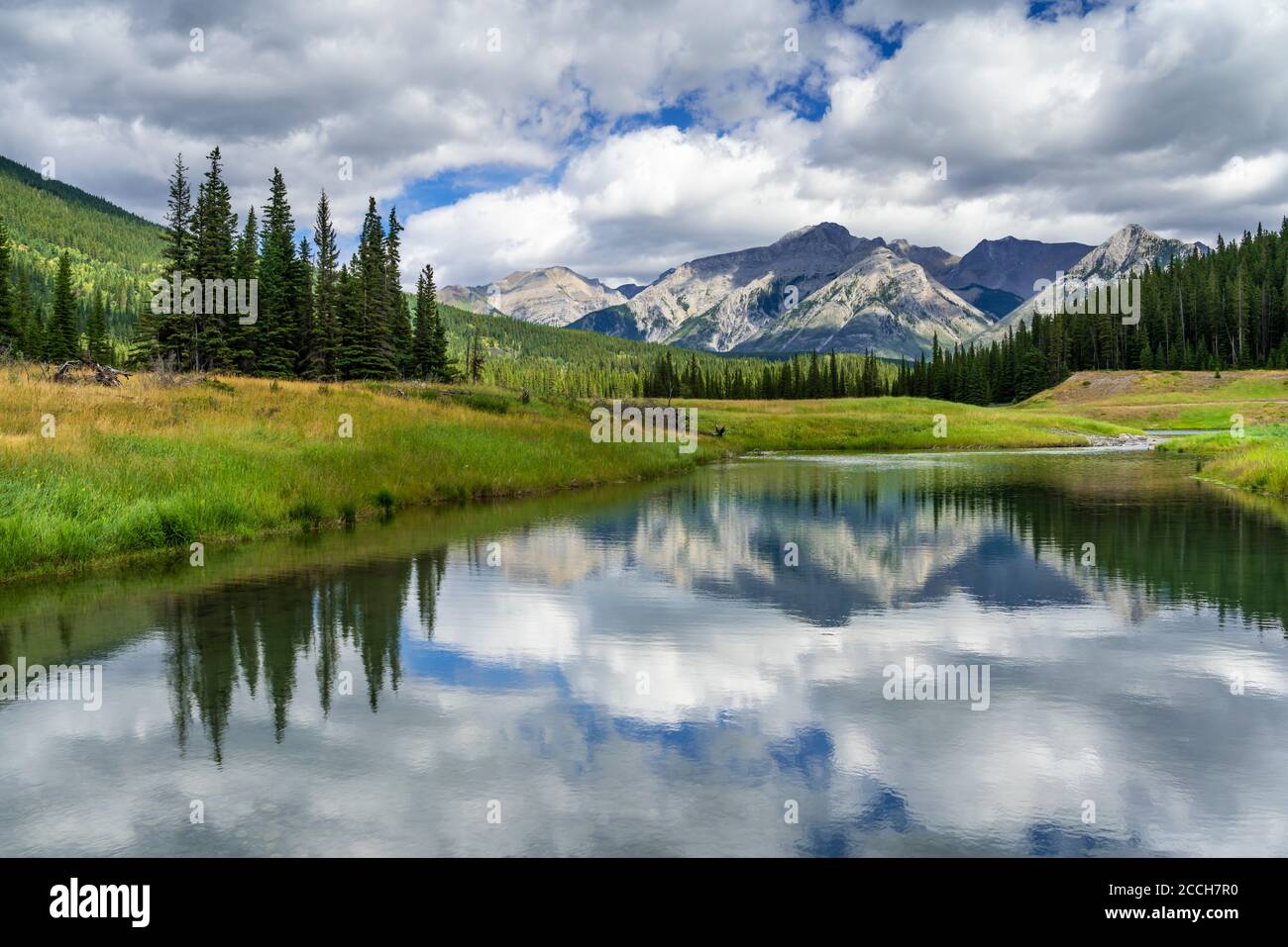 Scenic mountain reflections with a meadow near Lake Minnewanka, Banff ...