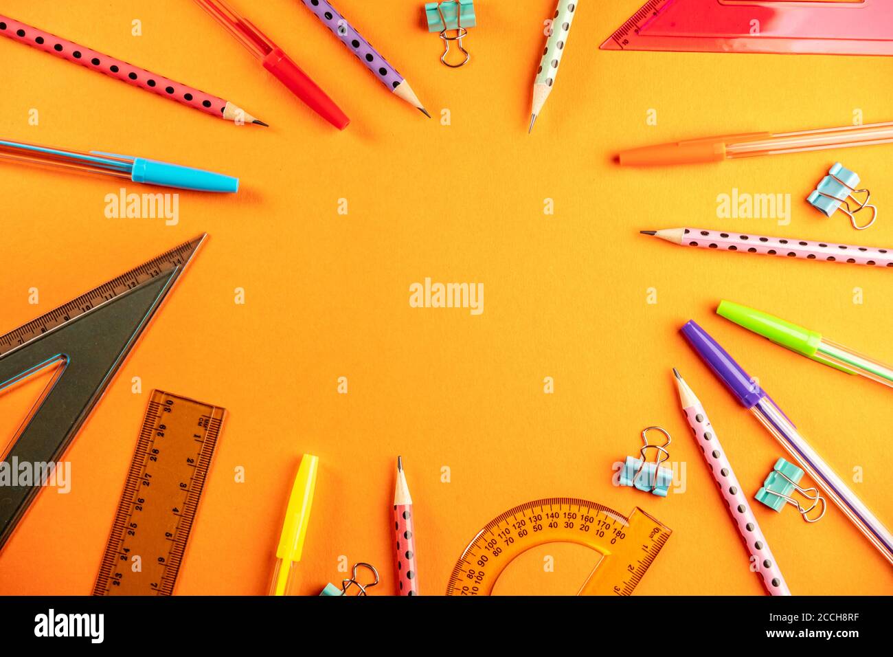 Colorful school stationery items on a orange background. Top view. Back ...
