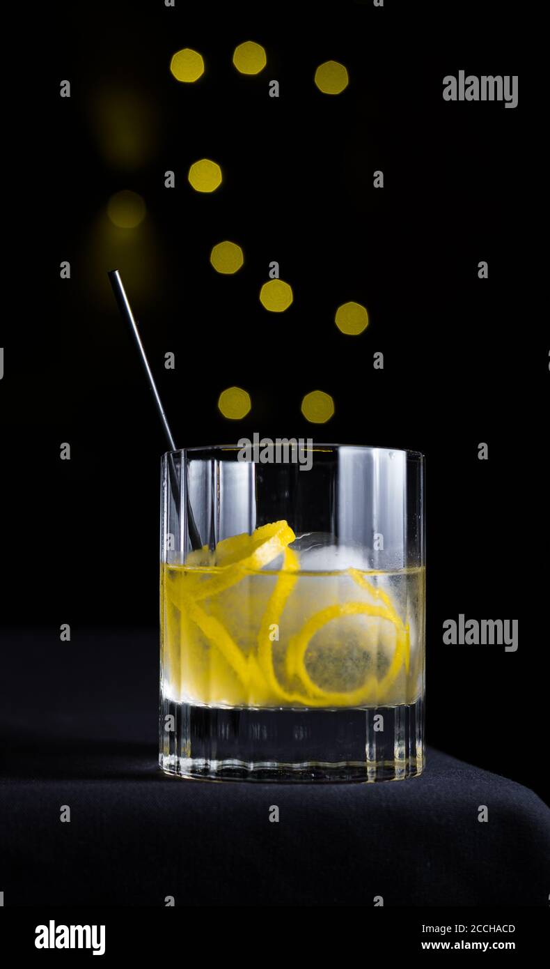 Craft cocktail in rocks glass w/ ice sphere & lemon garnish isolated on ...