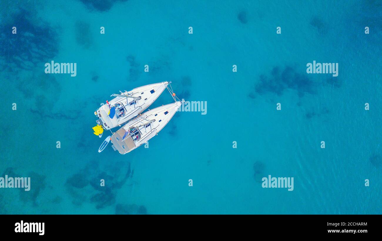 Aerial view of two sailing boats anchoring next to reef. Bird eye view ...