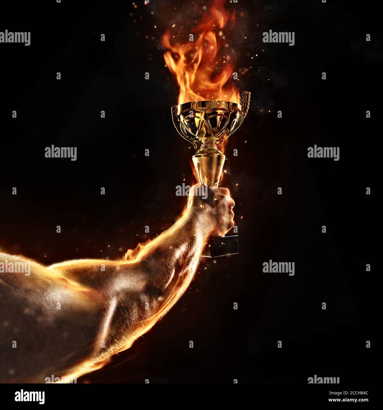Muscular man arm holding burning trophy cup on black background. Detail ...