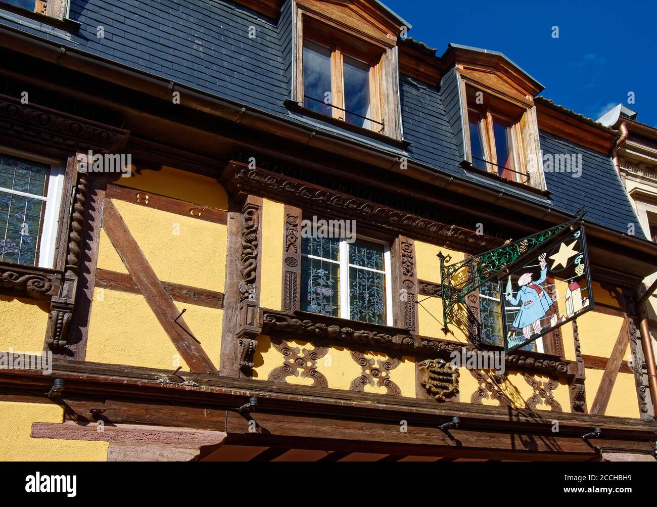 ornately carved building, half-timbered, weathered wood, metal sign ...