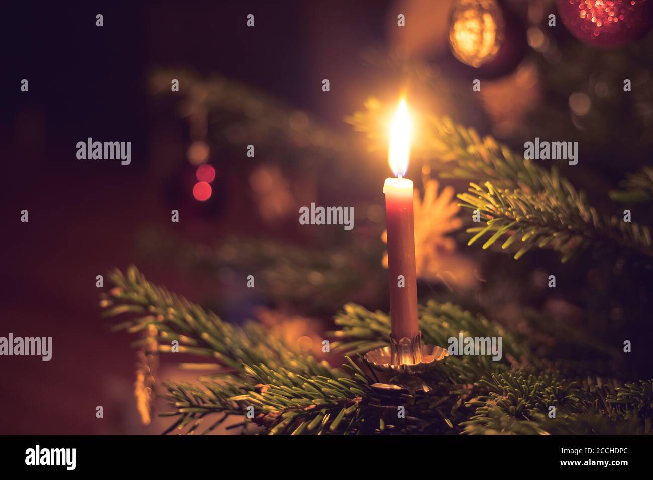 Candle on a branch of a decorated Christmas tree Stock Photo - Alamy
