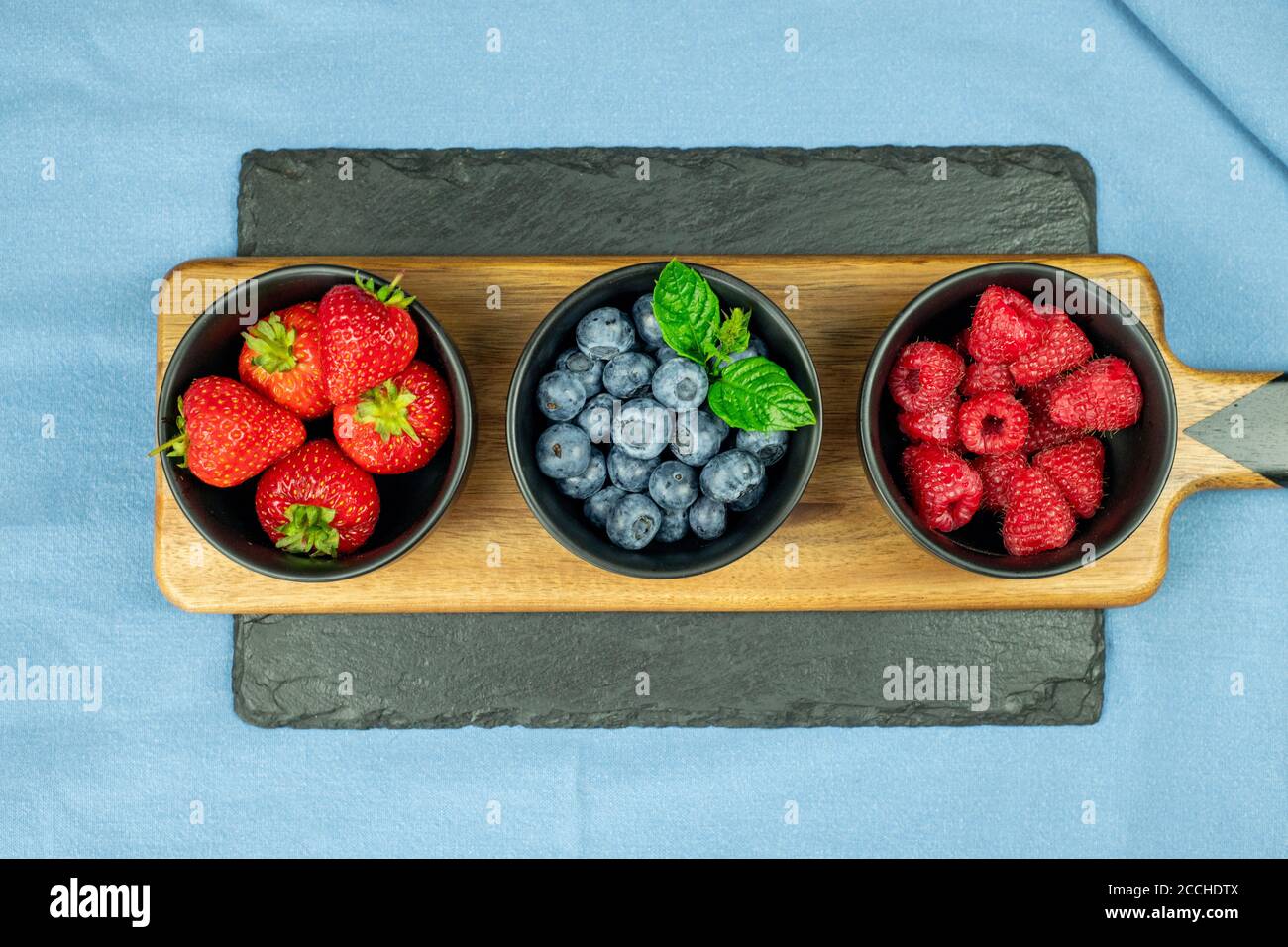 Selection of fruit strawberries blueberries and raspberries on a food ...