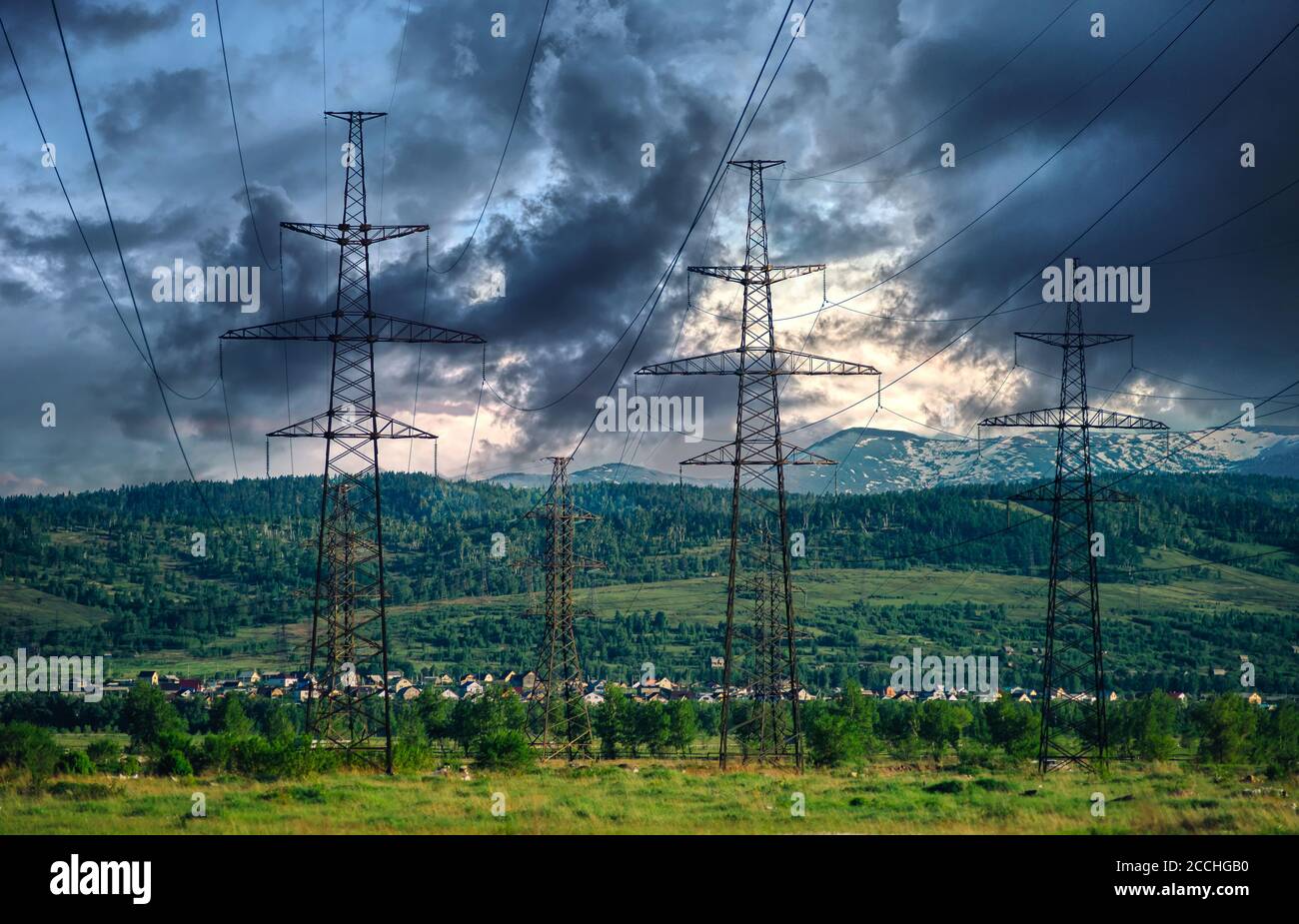 Transmission towers in the mountains under the sunset sky. high-voltage ...