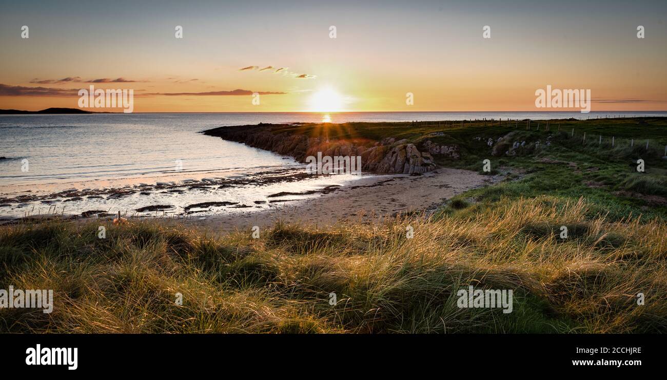 Sun setting on the sand dunes at Ballyheirnan Beach in Donegal Ireland ...