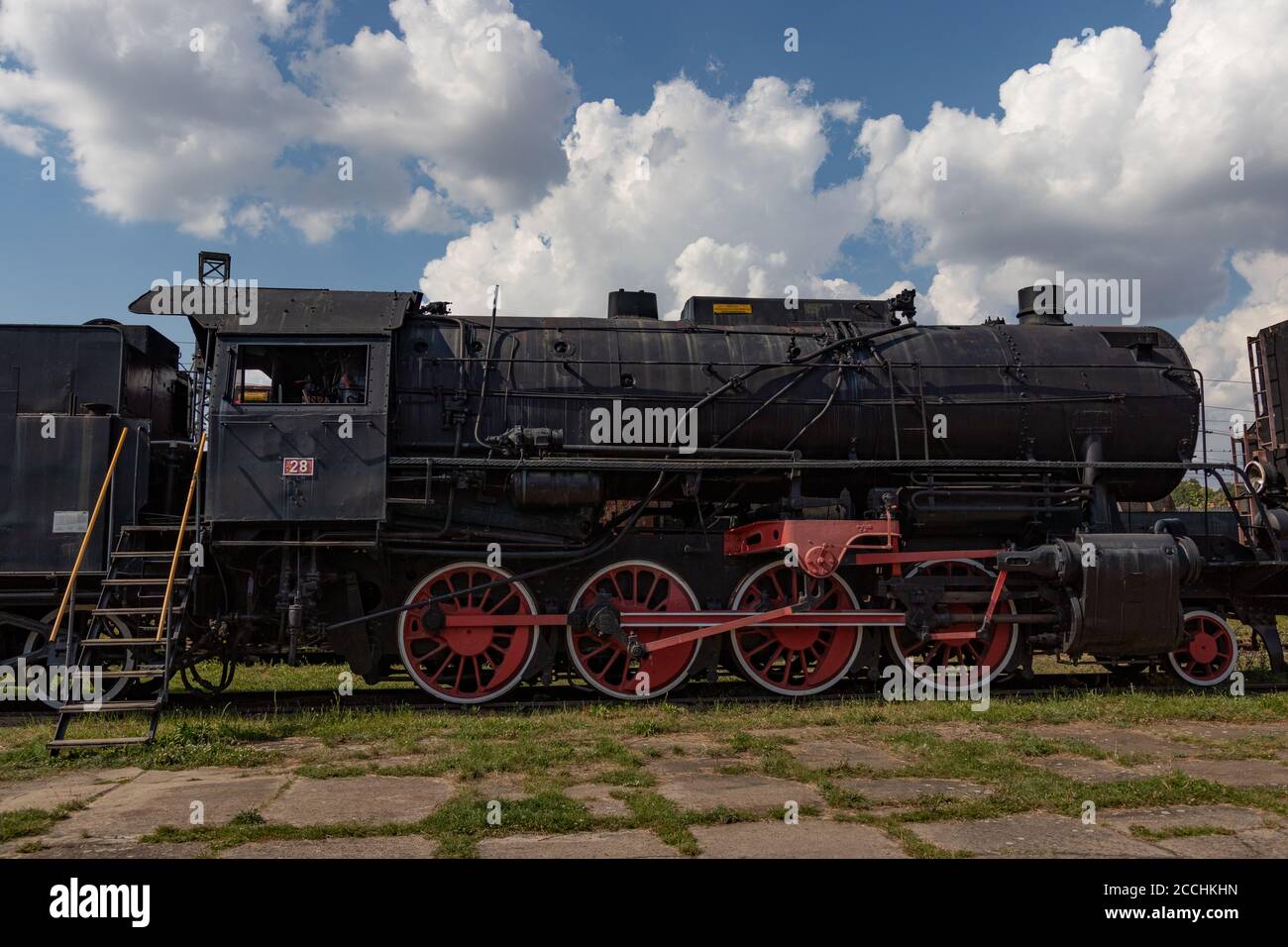 vintage steam engine train under sunny blue sky with clouds Stock Photo ...