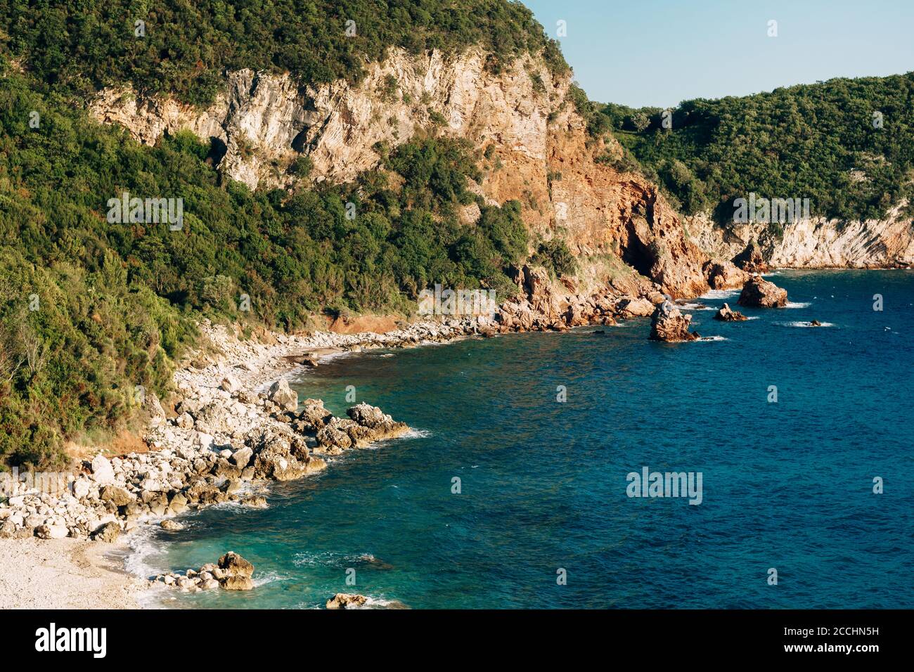 Paradise is a rocky beach in Montenegro. Blue sea water and mountains ...