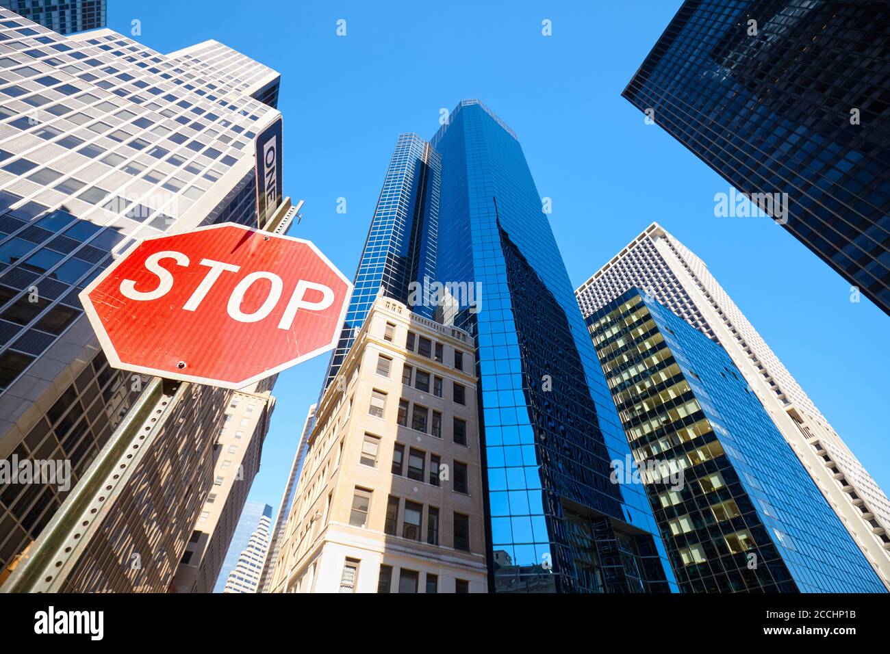 Looking up at stop sign on a street of New York City with modern ...