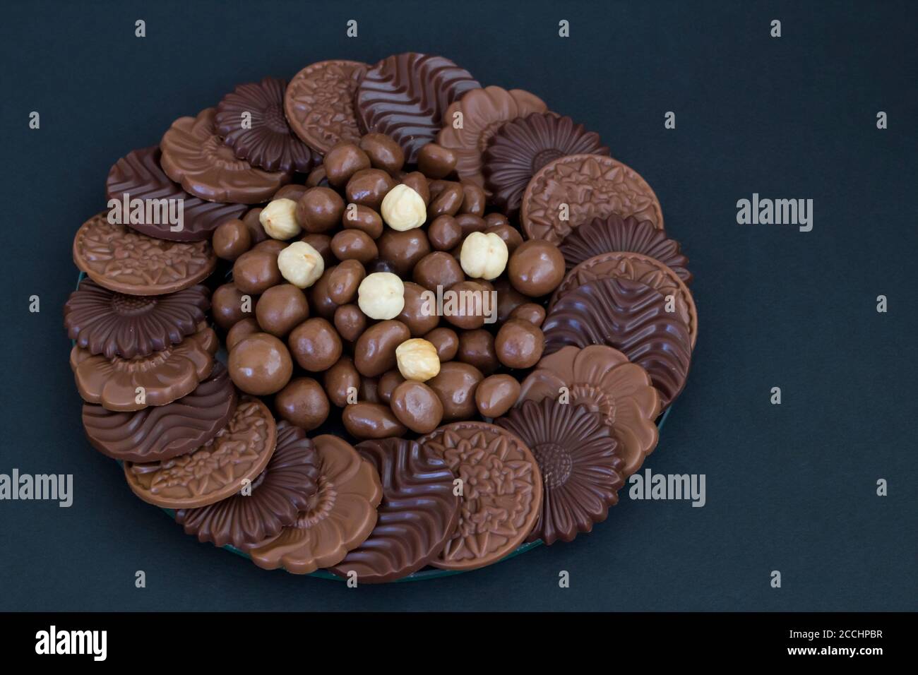 Milky and bitter round shape chocolate Madlen,designed on glass plate ...