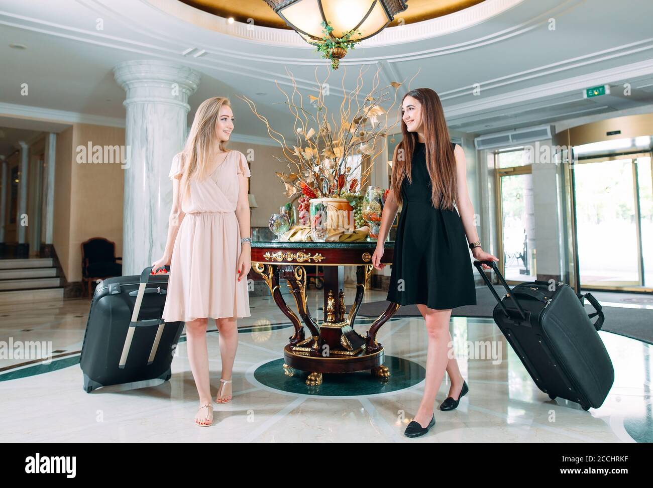 Young girls near reception desk in hotel. Young girls comes to the ...