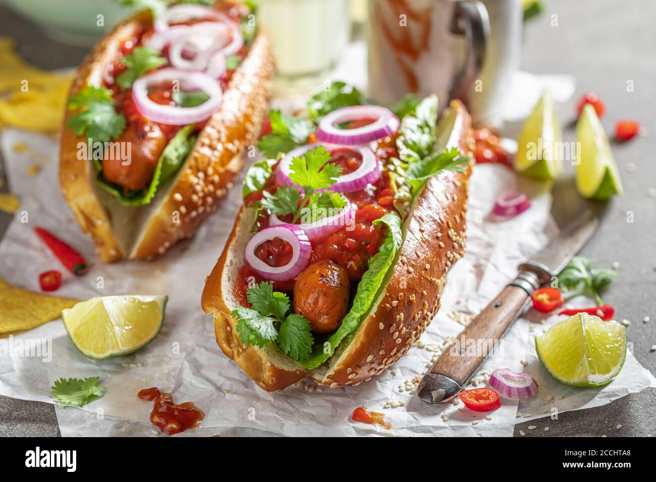 Unhealthy barbecue hot dogs served with nachos and lemonade Stock Photo ...