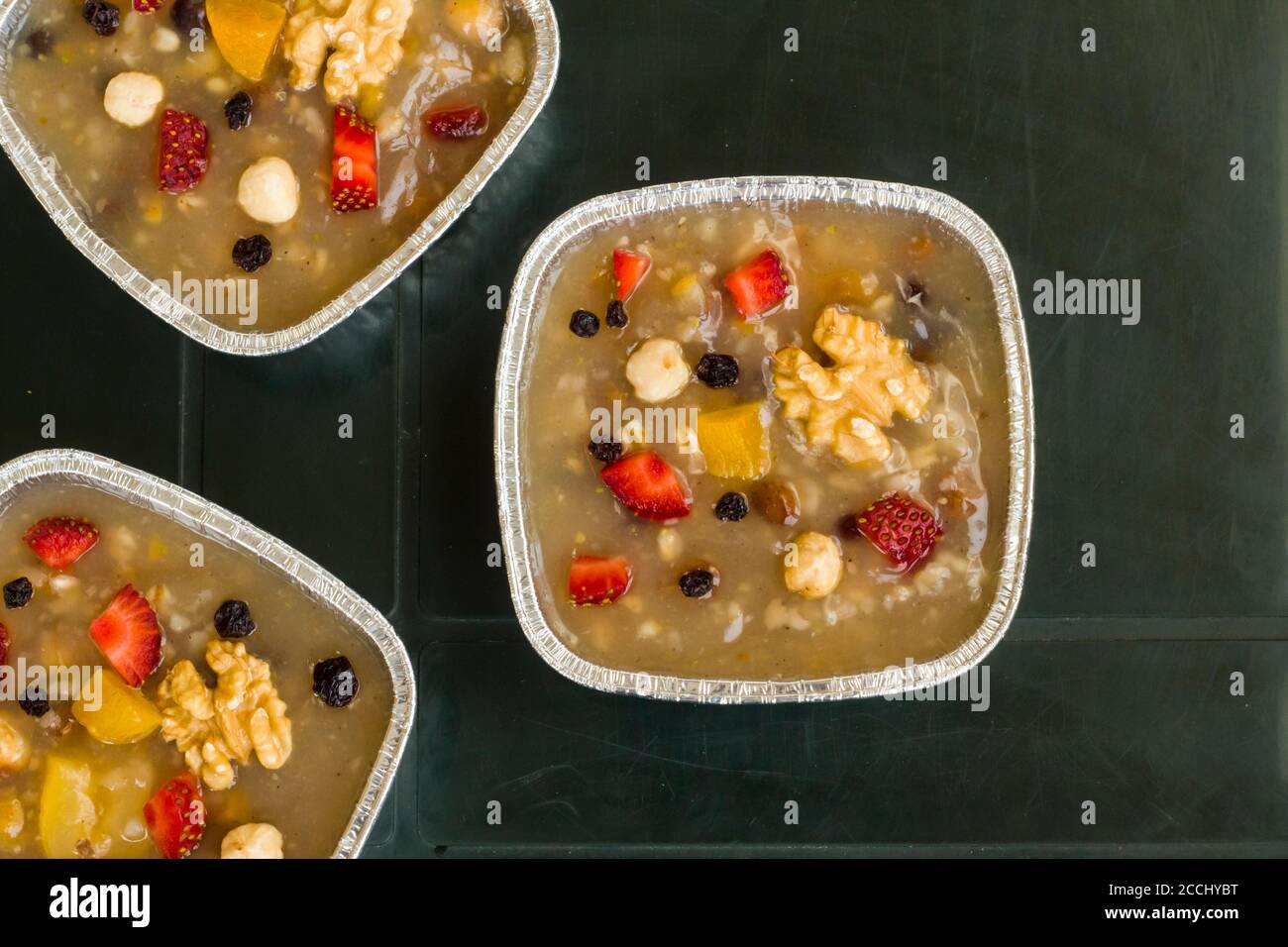 Traditional Turkish Dessert Asure on table in aluminum bowls,foil ...