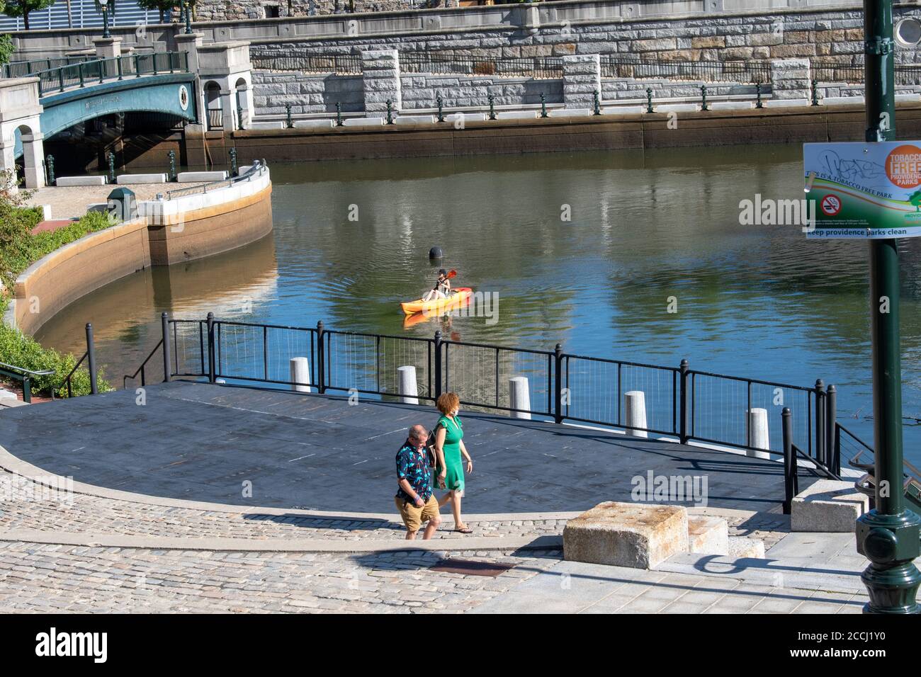 Kayaker paddles along the Providence river as couple strolls along the ...