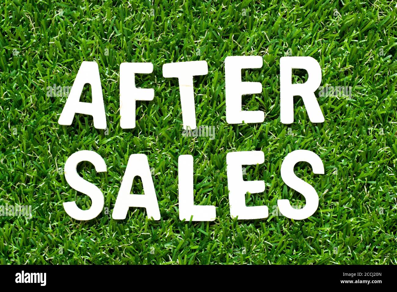 Wood alphabet letter in word after sales on green grass background ...