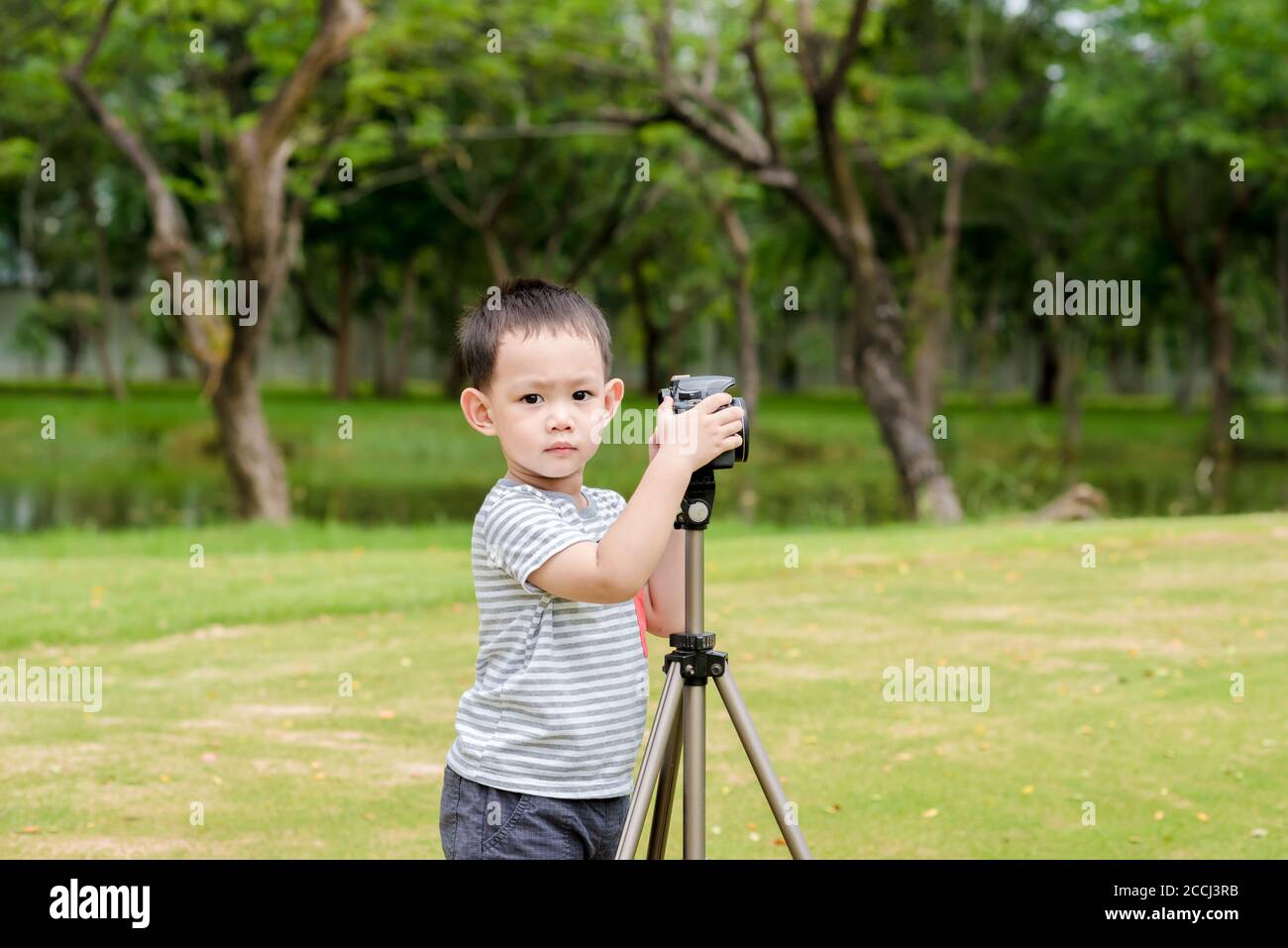 Asian baby boy taking photo graphy in nature by DSLR camera and tripods ...