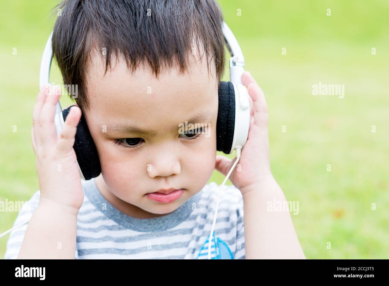 Asian baby boy listening music by headphone Stock Photo - Alamy