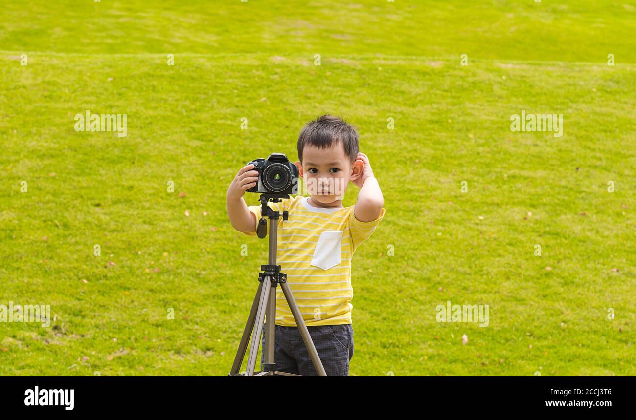 Asian baby boy taking photo graphy in nature by DSLR camera and tripods ...