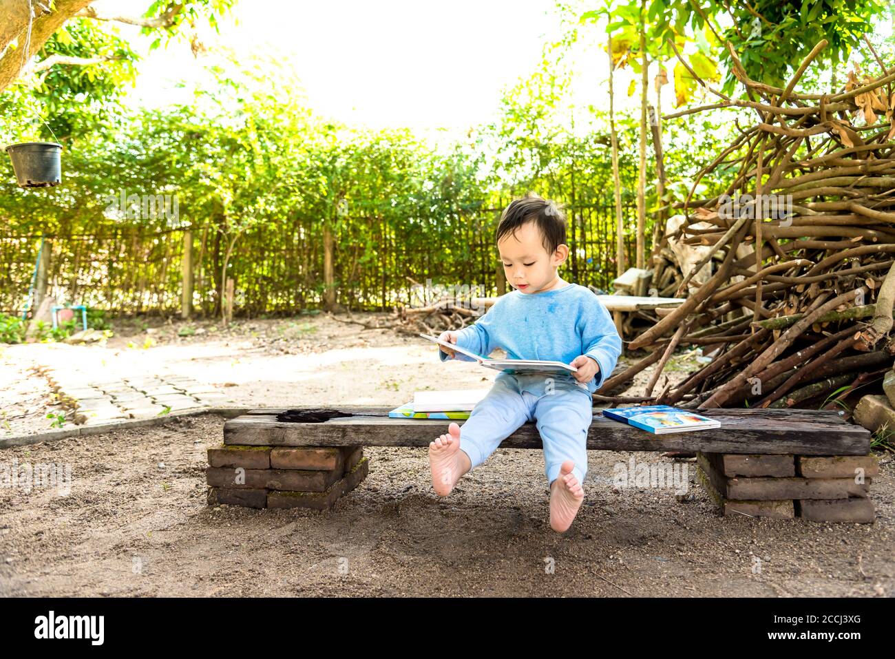 Asian baby boy reading tale book alone at outdoor Stock Photo - Alamy