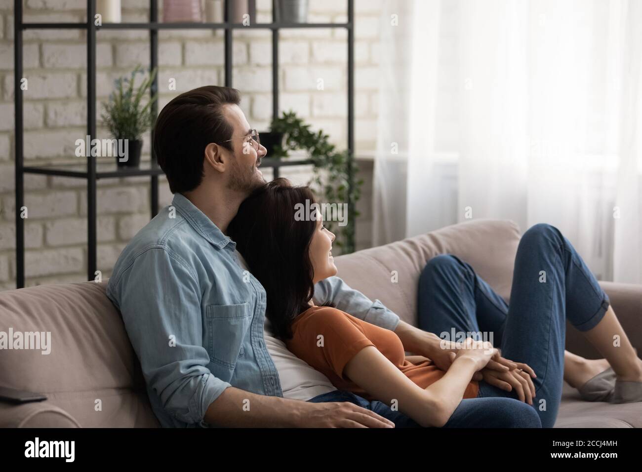 Happy couple relax cuddle on comfortable sofa at home Stock Photo - Alamy