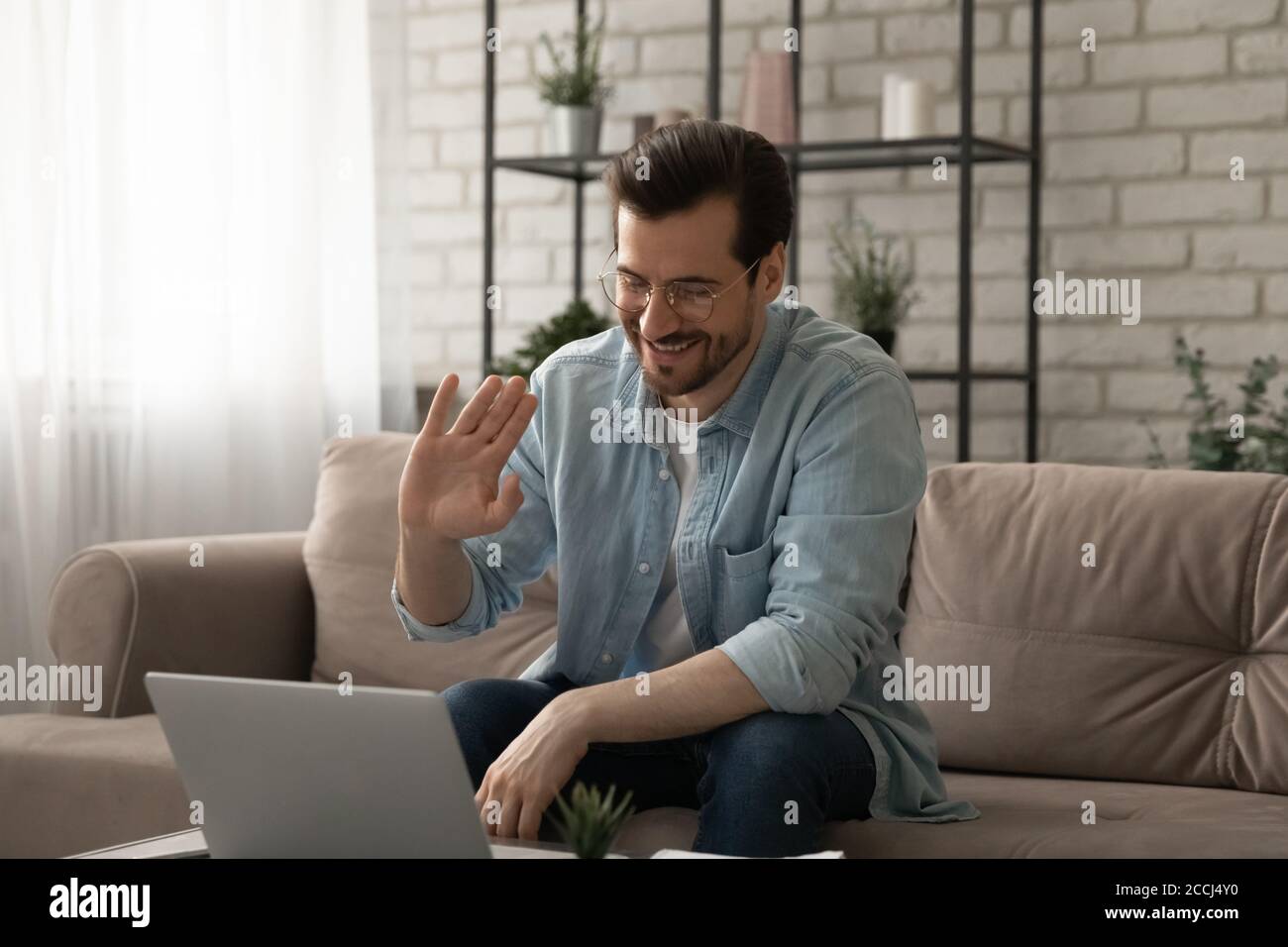 Smiling man wave talking on video call on computer Stock Photo - Alamy