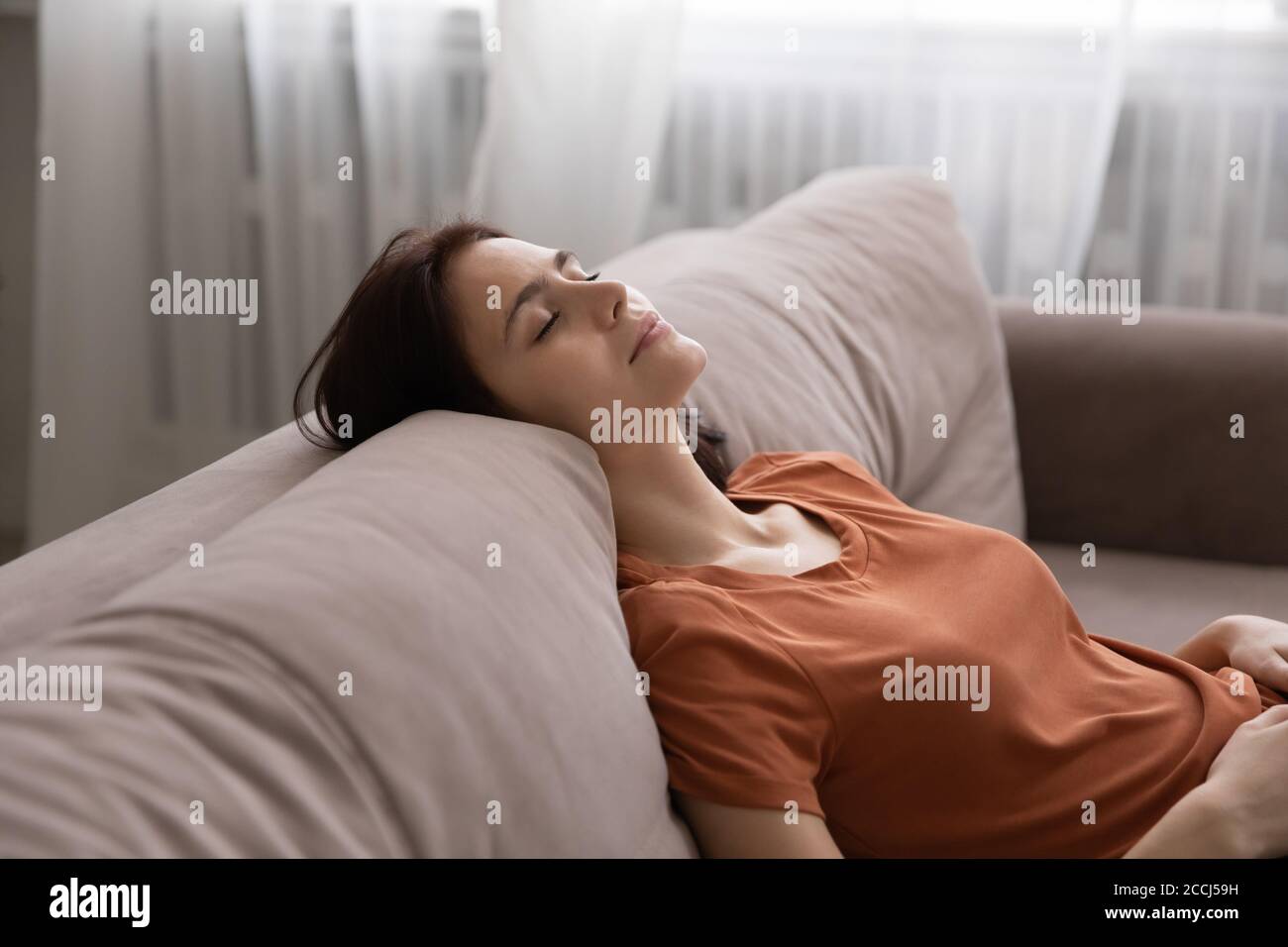 Woman taking nap on sofa hi-res stock photography and images - Alamy