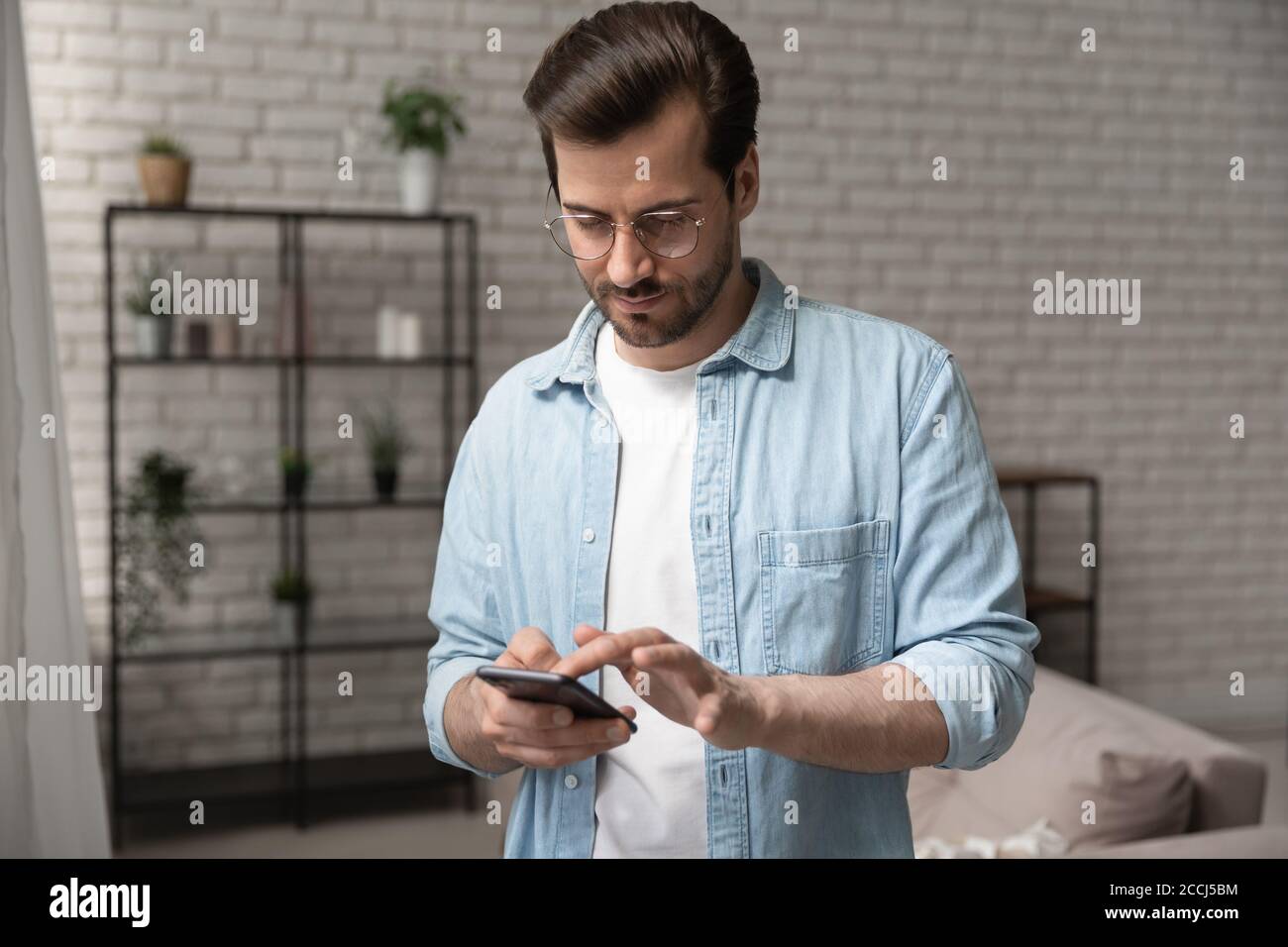 Young caucasian man browsing modern smartphone at home Stock Photo - Alamy
