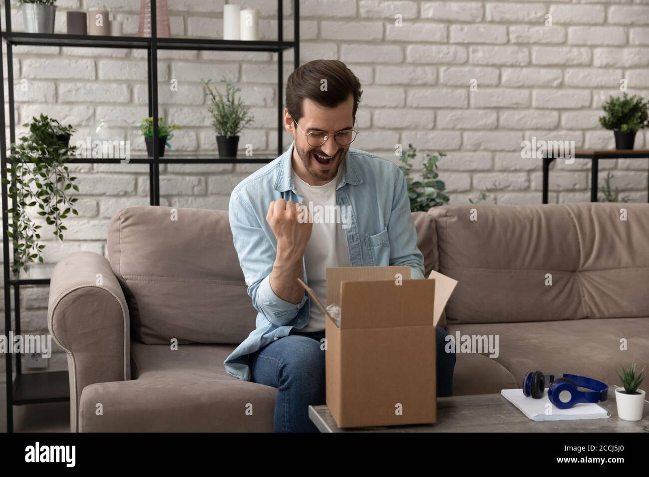 Excited man unpack order satisfied with quality product Stock Photo - Alamy