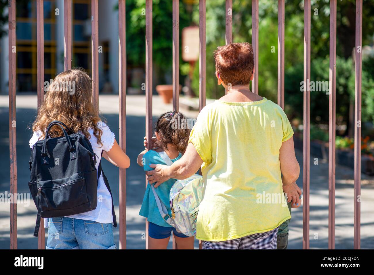 Children With Grandmother Wait Outisde A Closed School Gate. Back to ...