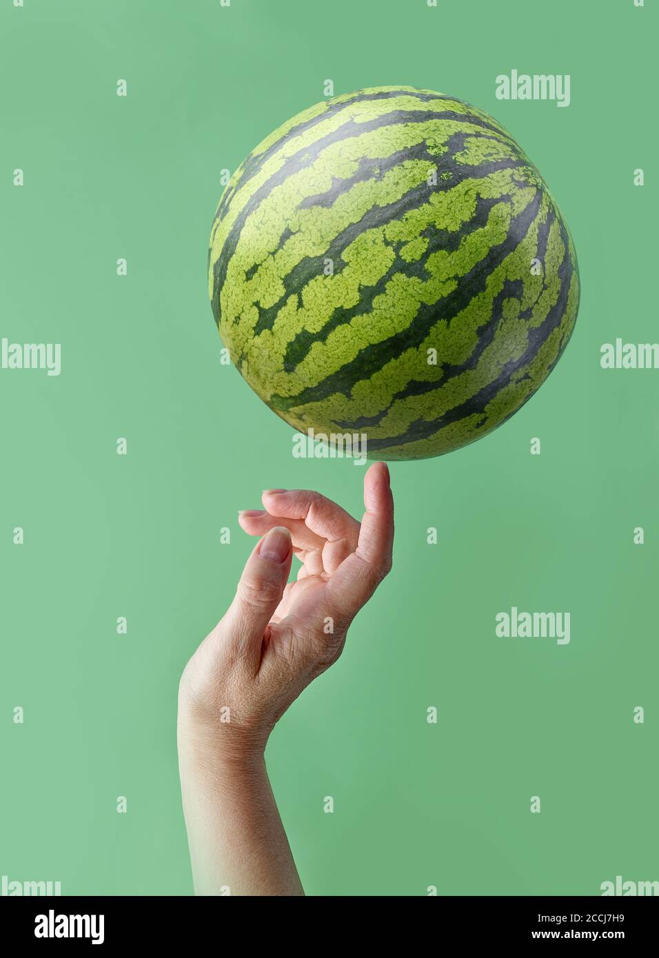 watermelon and human hand isolated on green background Stock Photo - Alamy