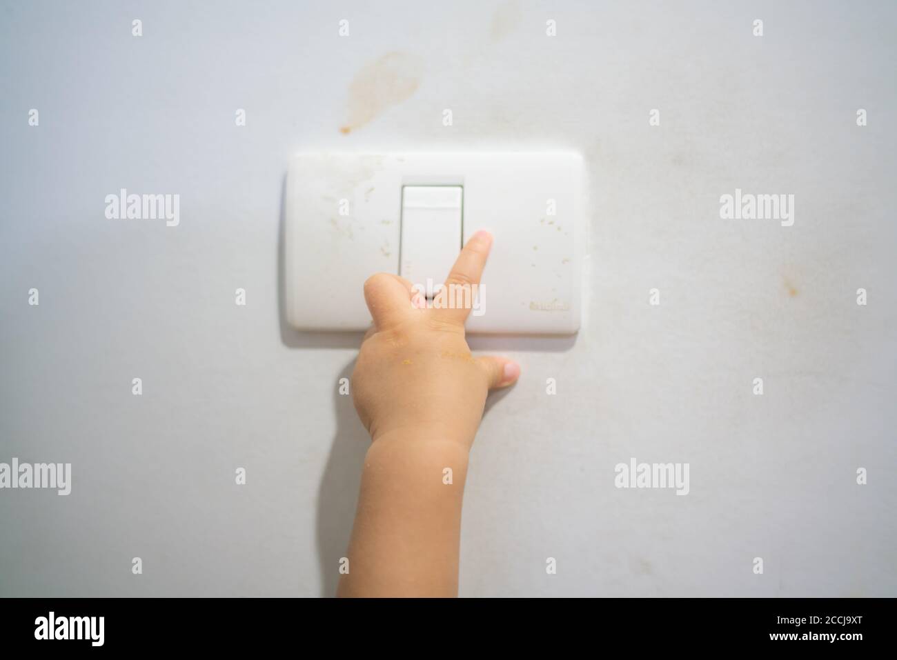 Baby boy playing electric socket lamp plug in room danger child Stock ...