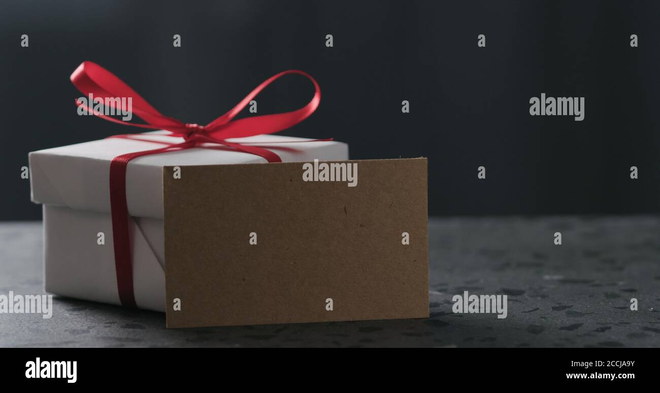 empty paper card next to white gift box on terrazzo countertop, wide ...