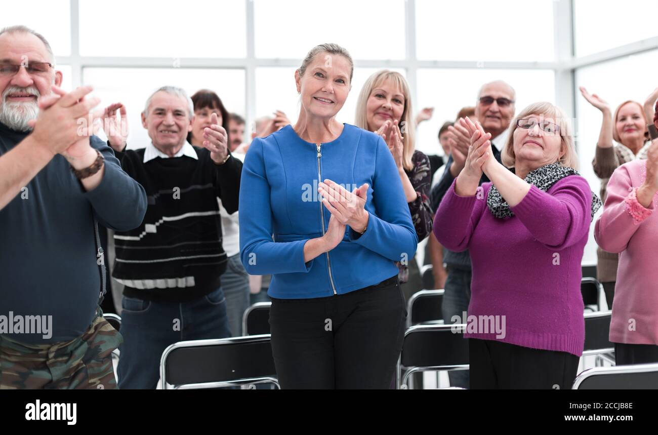 a group of elderly people are sitting in a circle clapping their Stock ...