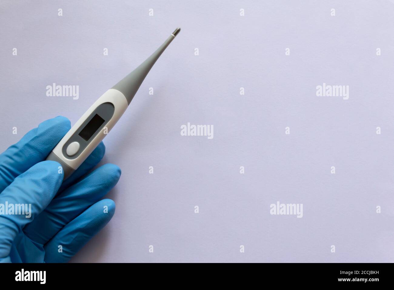 Doctor's Hand in Blue Latex Glove Hold a White Electronic Thermometer ...