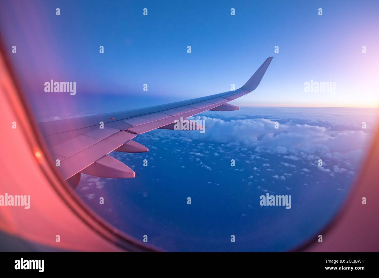 View from passenger's seat in airplane flying above clouds in dramatic ...