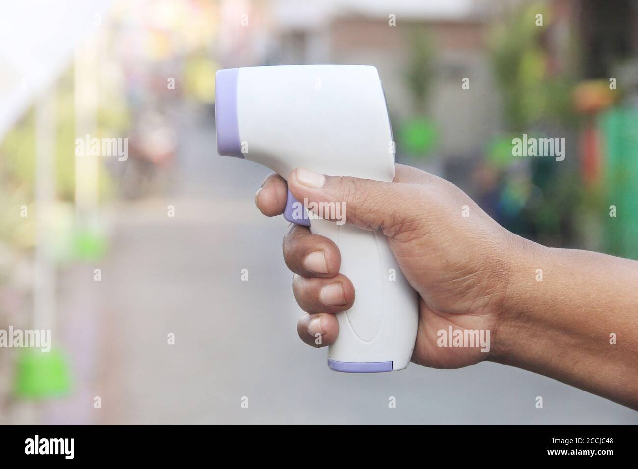 a man's hand holding a digital body temperature detection device Stock ...