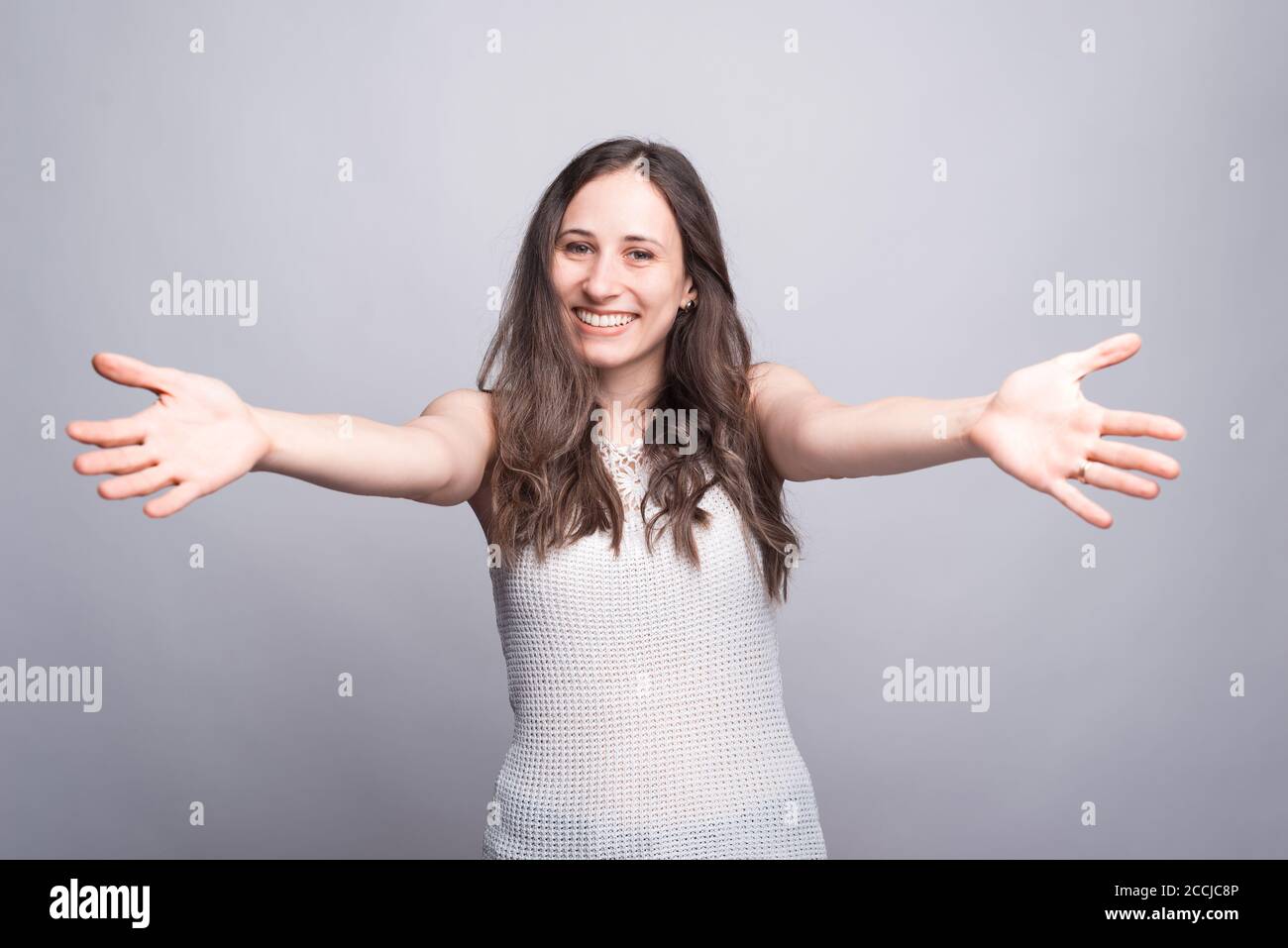Photo of young smiling woman making welcome gesture over white ...
