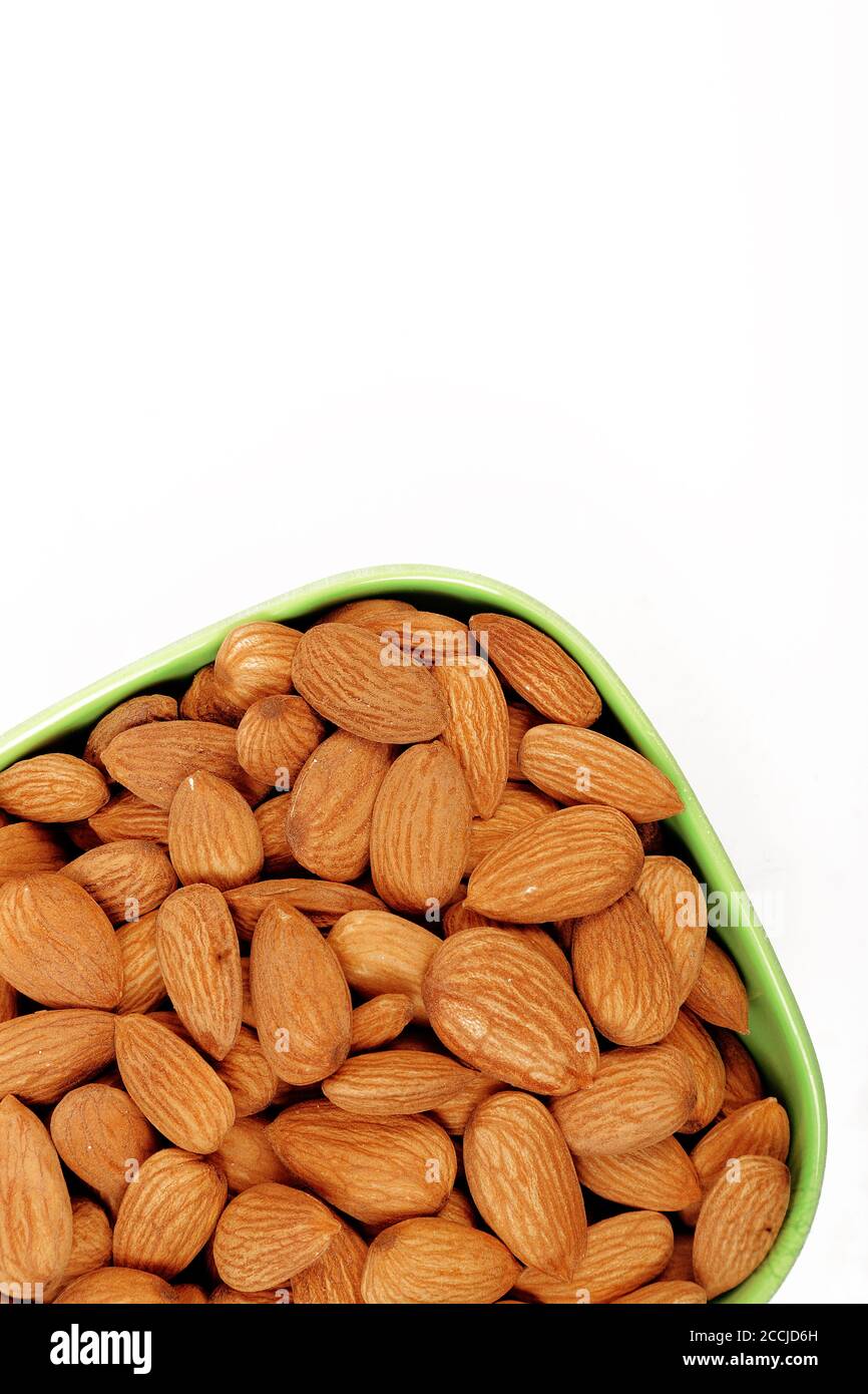 Group of almonds inside and outside bowl isolated on white Stock Photo ...