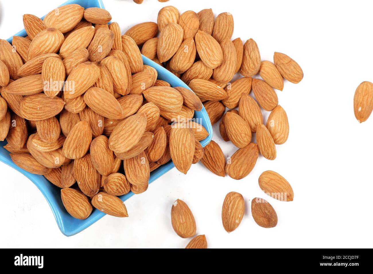 Group of almonds inside and outside bowl isolated on white Stock Photo ...