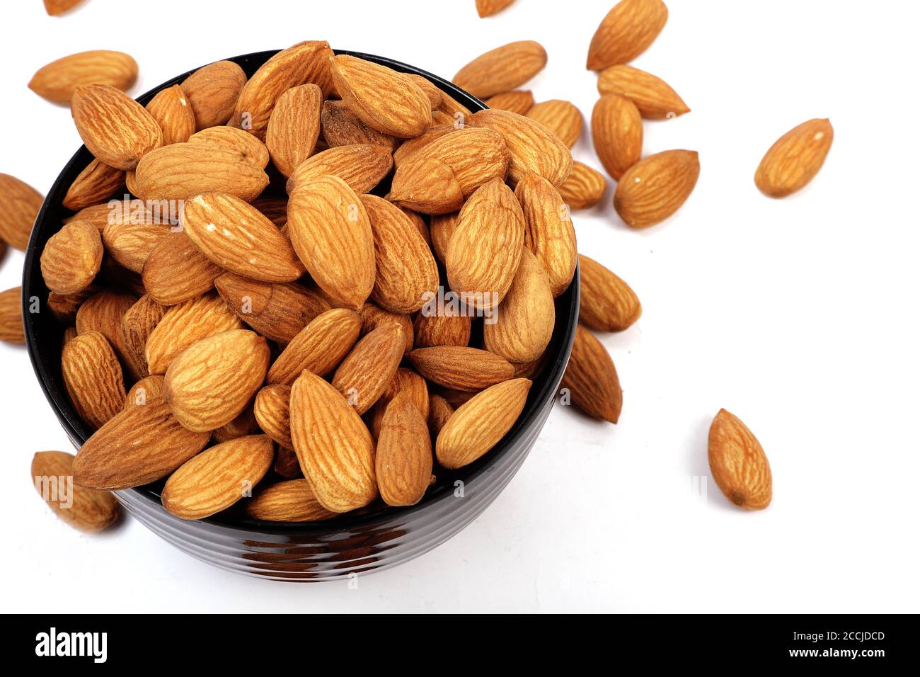 Group of almonds inside and outside bowl isolated on white Stock Photo ...