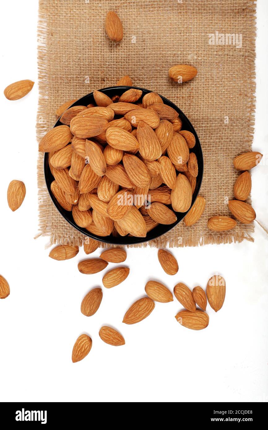 Group of almonds inside and outside bowl isolated on white Stock Photo ...