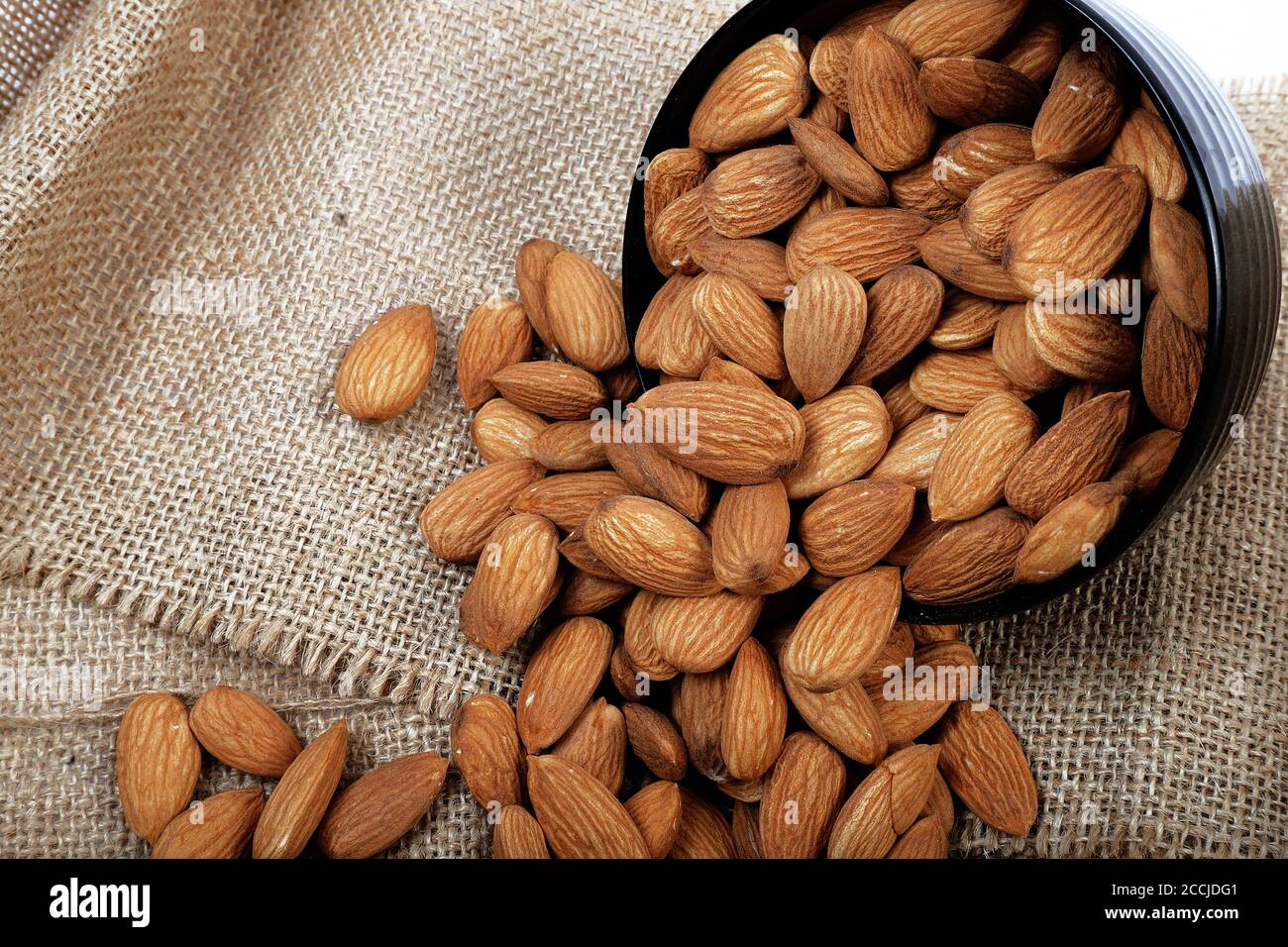 Group of almonds inside and outside bowl isolated on white Stock Photo ...