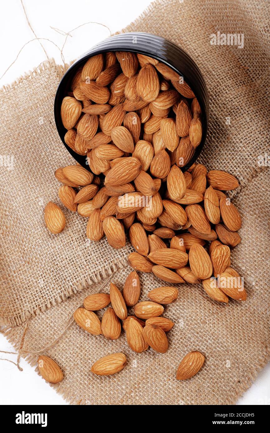 Group of almonds inside and outside bowl isolated on white Stock Photo ...