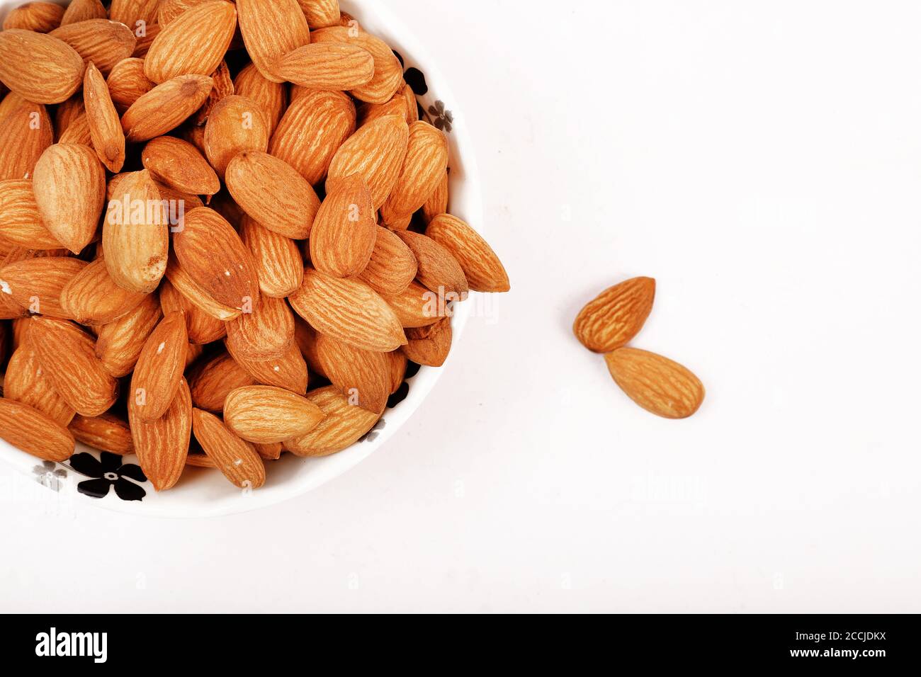 Group of almonds inside and outside bowl isolated on white Stock Photo ...