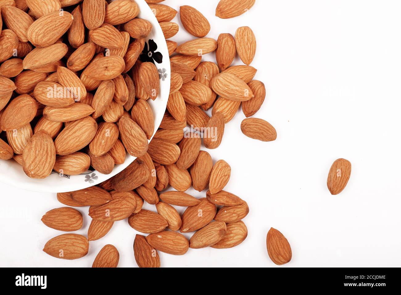 Group of almonds inside and outside bowl isolated on white Stock Photo ...